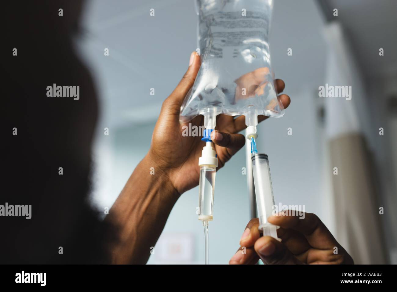 Close up of african american male doctor applying drip in hospital room ...
