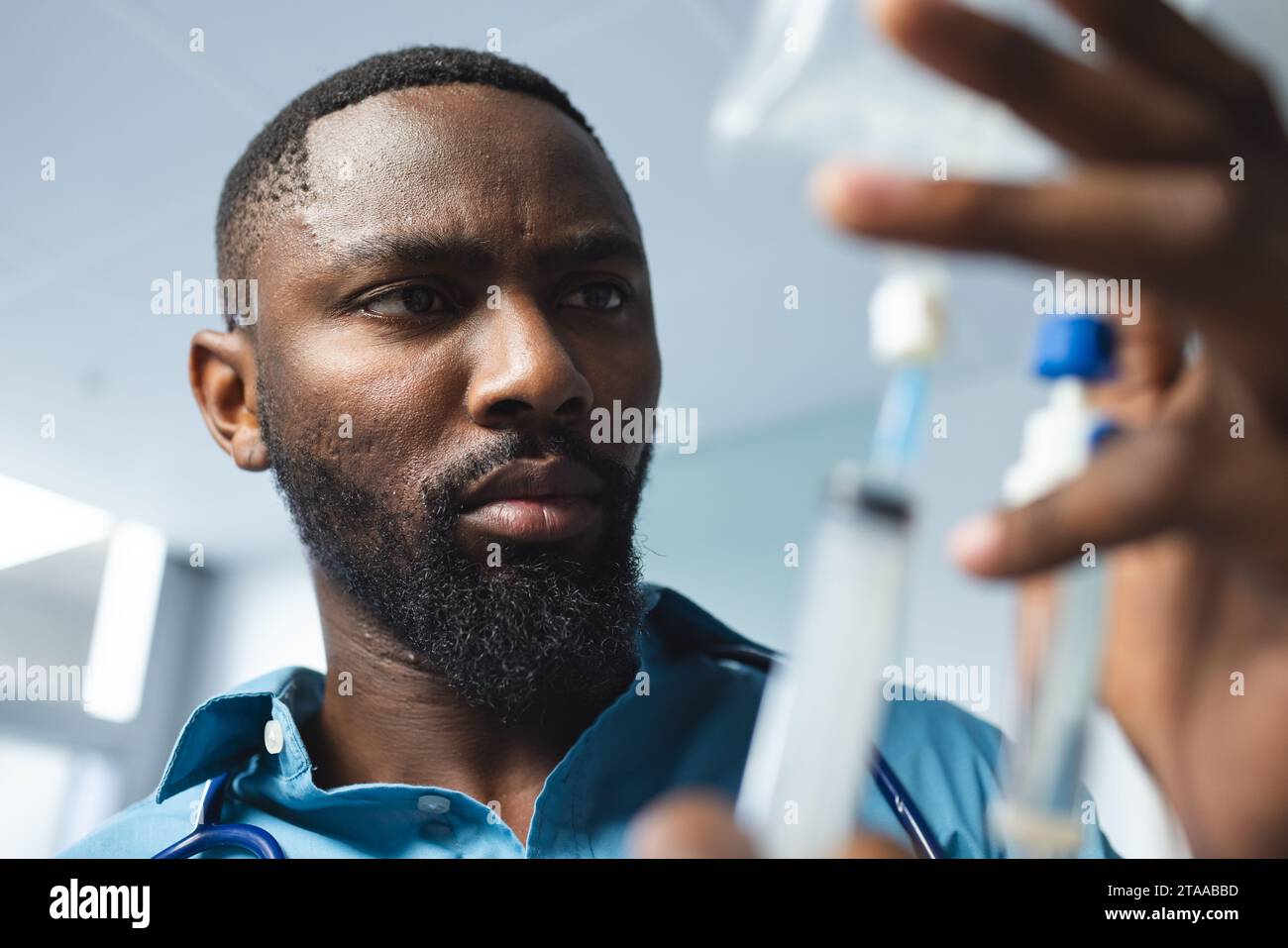 African american male doctor wearing blue shirt applying drip in ...