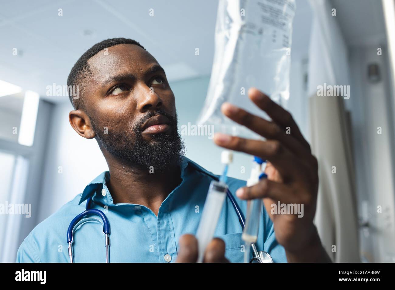 African american male doctor wearing blue shirt applying drip in ...