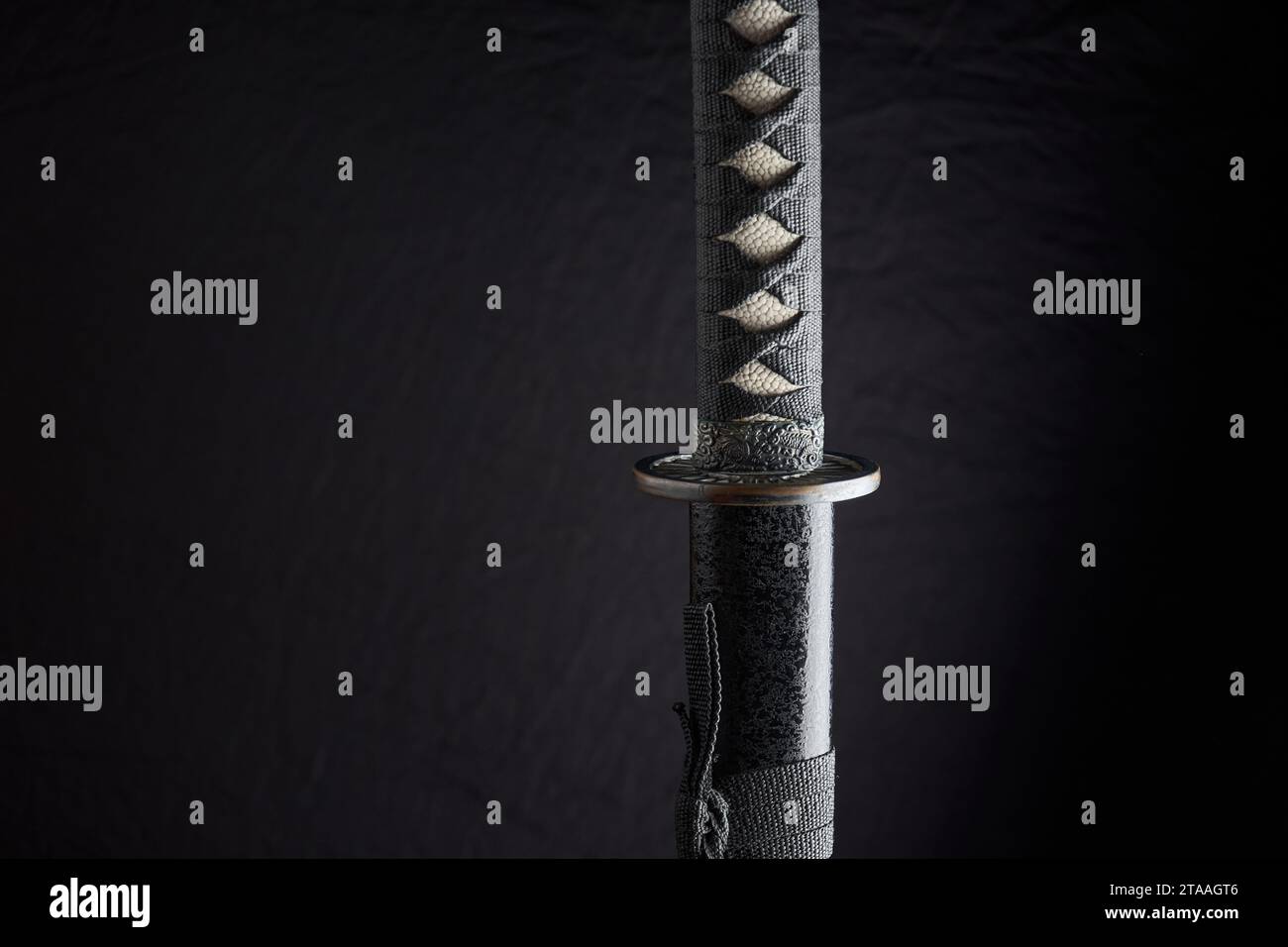 Horizontal photo of sheathed katana with details of the handle and ...