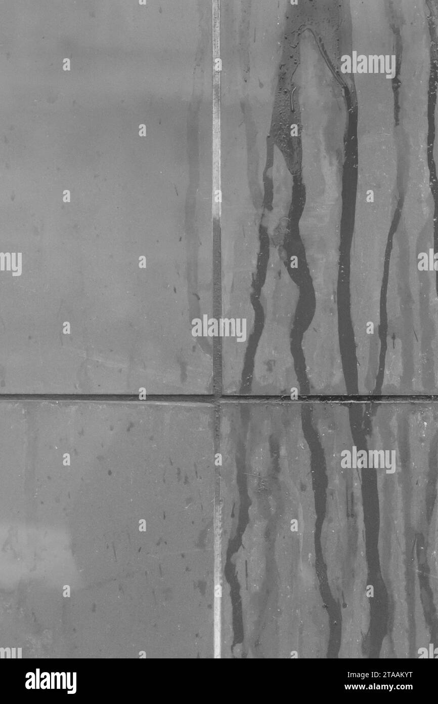 Grey streaks of paint spilled on the surface of ceramic tiles wall ...