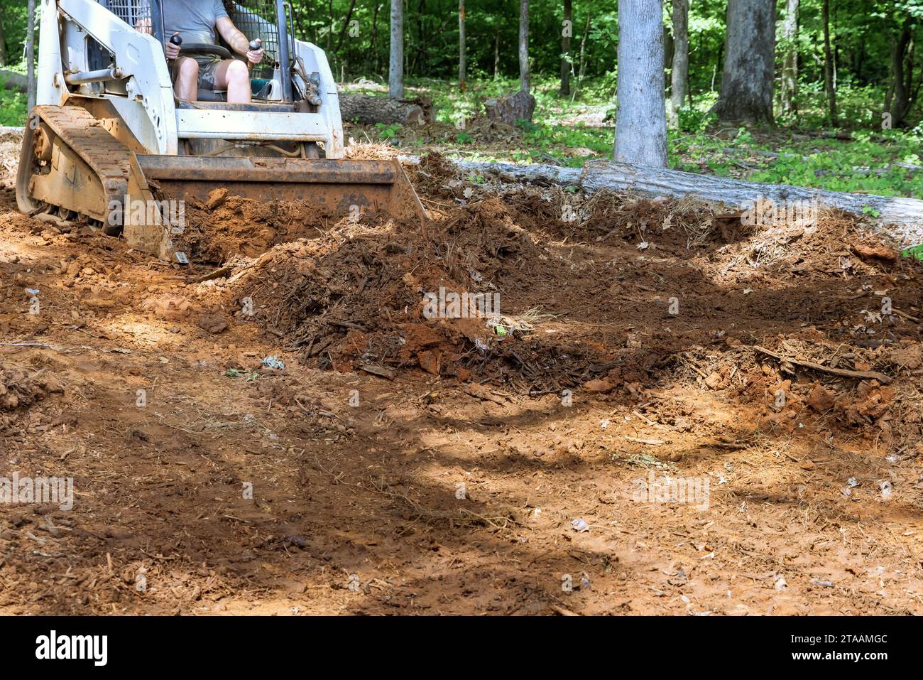 Work with earth, moving soil improving landscape of territory with mini ...