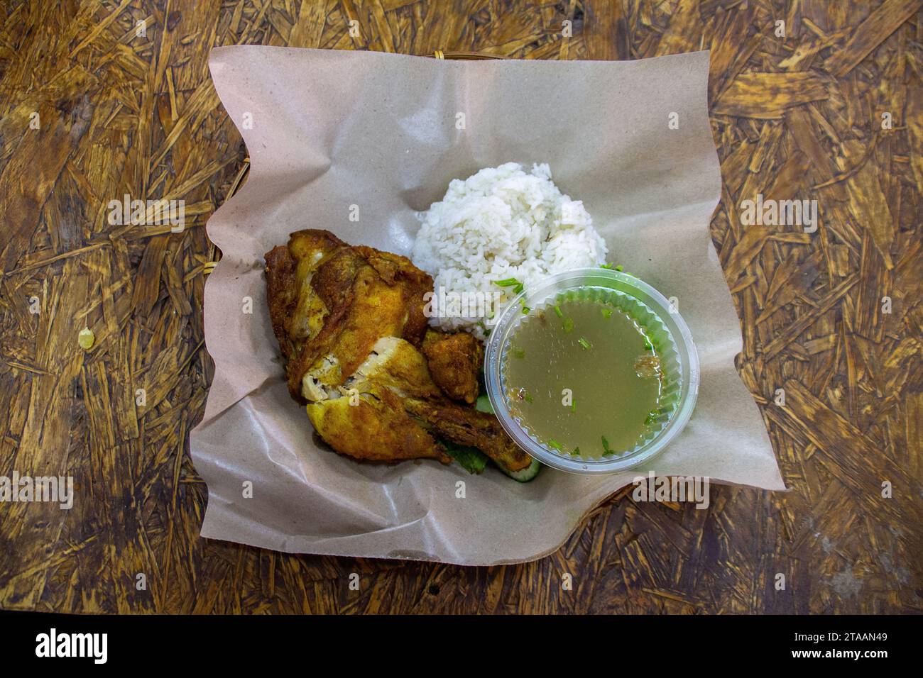 Fried chicken rice with soup in a wrap paper, a food of Kuala Lumpur ...