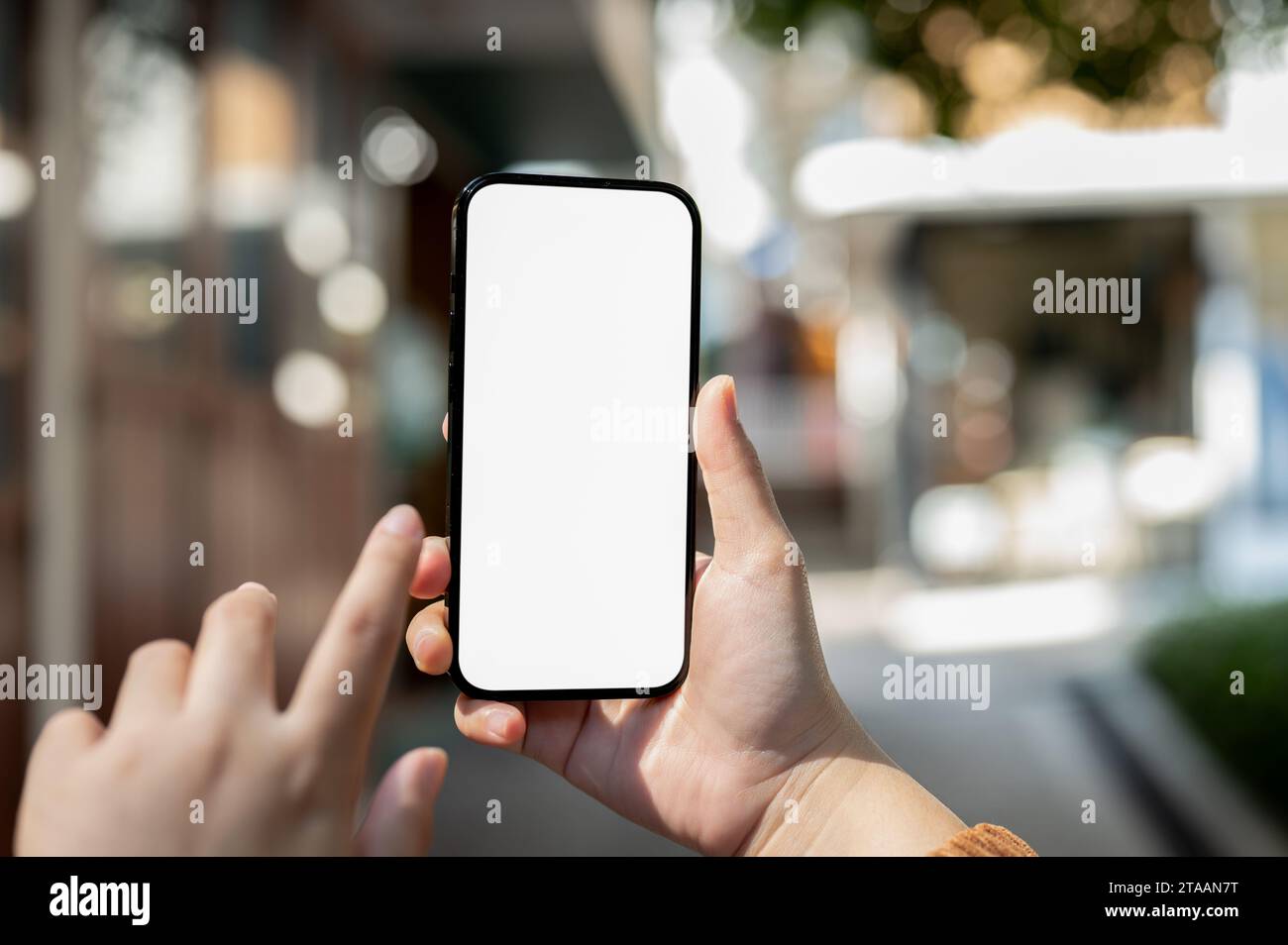 Close-up image of a white-screen smartphone mockup in a woman's hand ...
