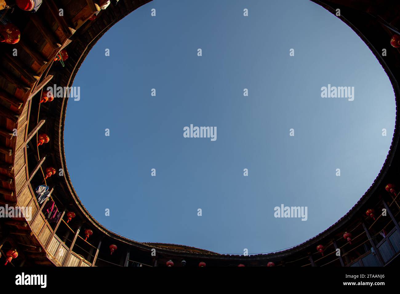 The sky above the round buildings of Hekeng Tulou Cluster in the early ...