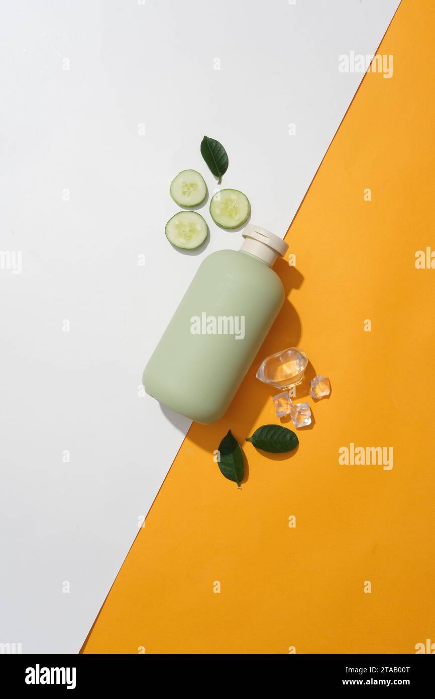 White and orange background featured a cosmetic tube with cucumber ...