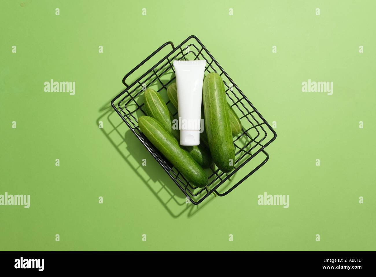 View from above of a black basket containing several cucumbers and a ...