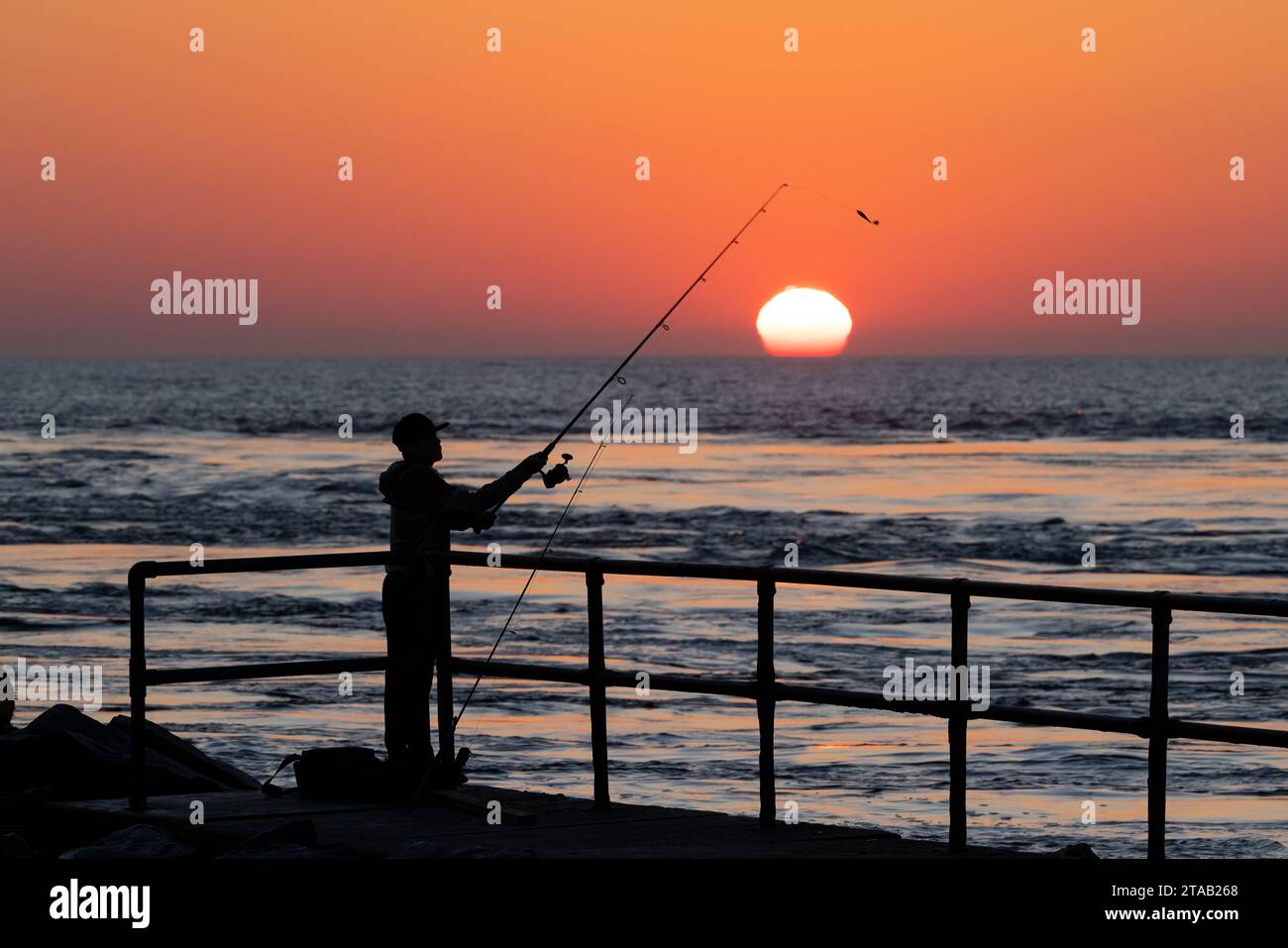Lone fisherman at Indian River Inlet at sunrise, Delaware Seashore ...