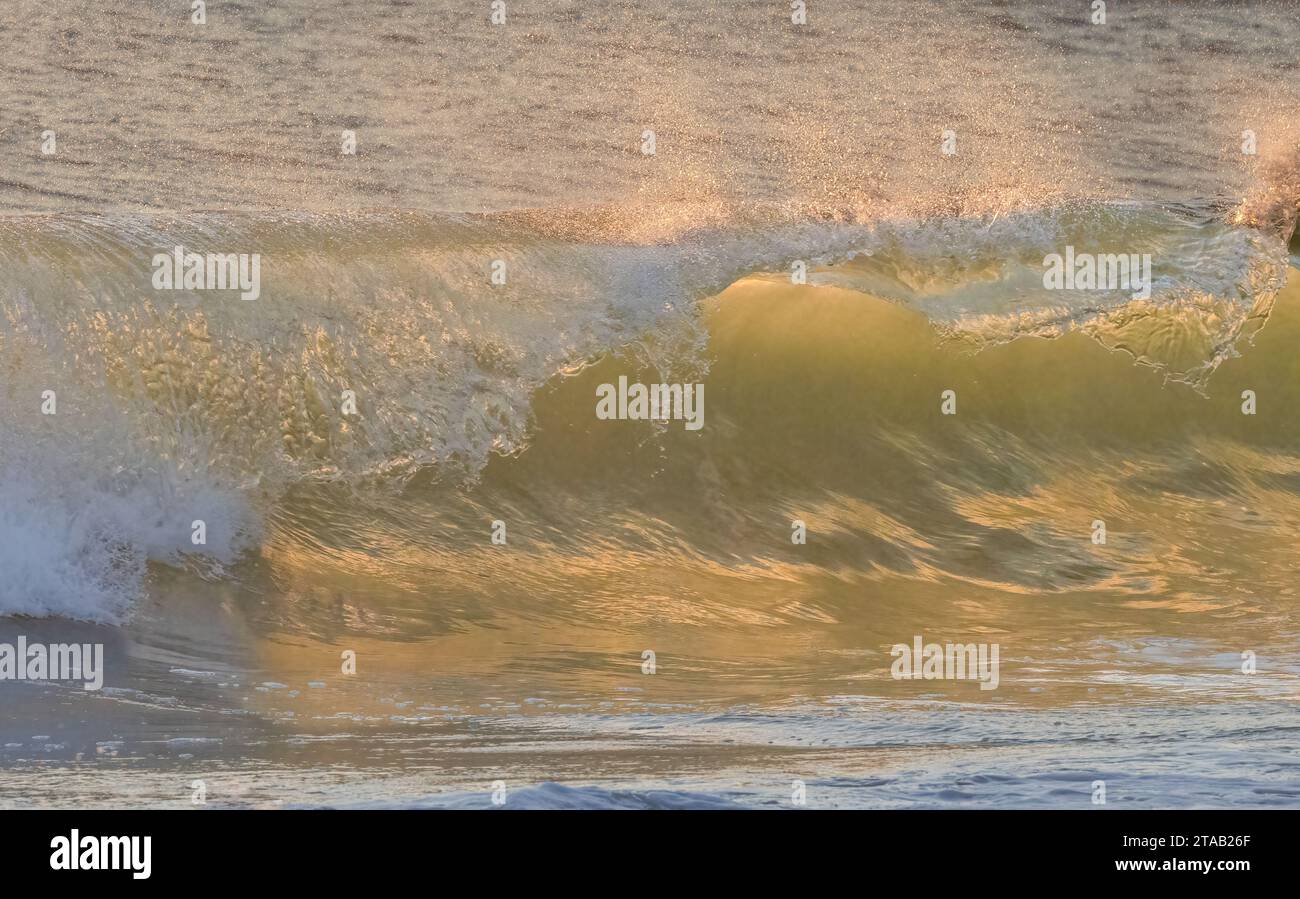 Sunrise light shining through a wave, Delaware Seashore State Park ...