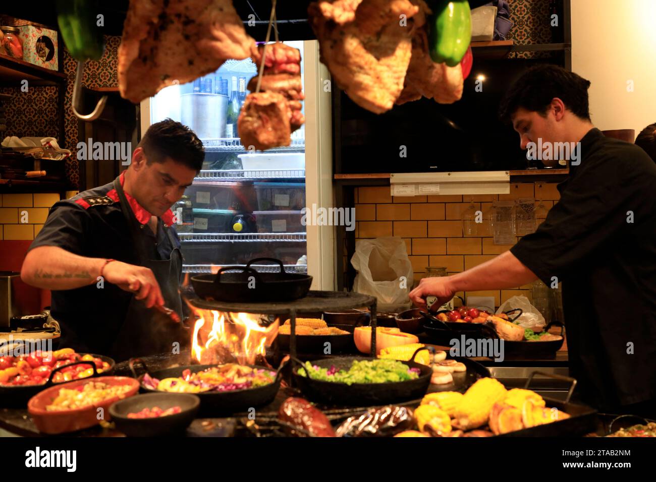 Cook preparing food in a open kitchen in San Telmo Market.Buenos Aires ...