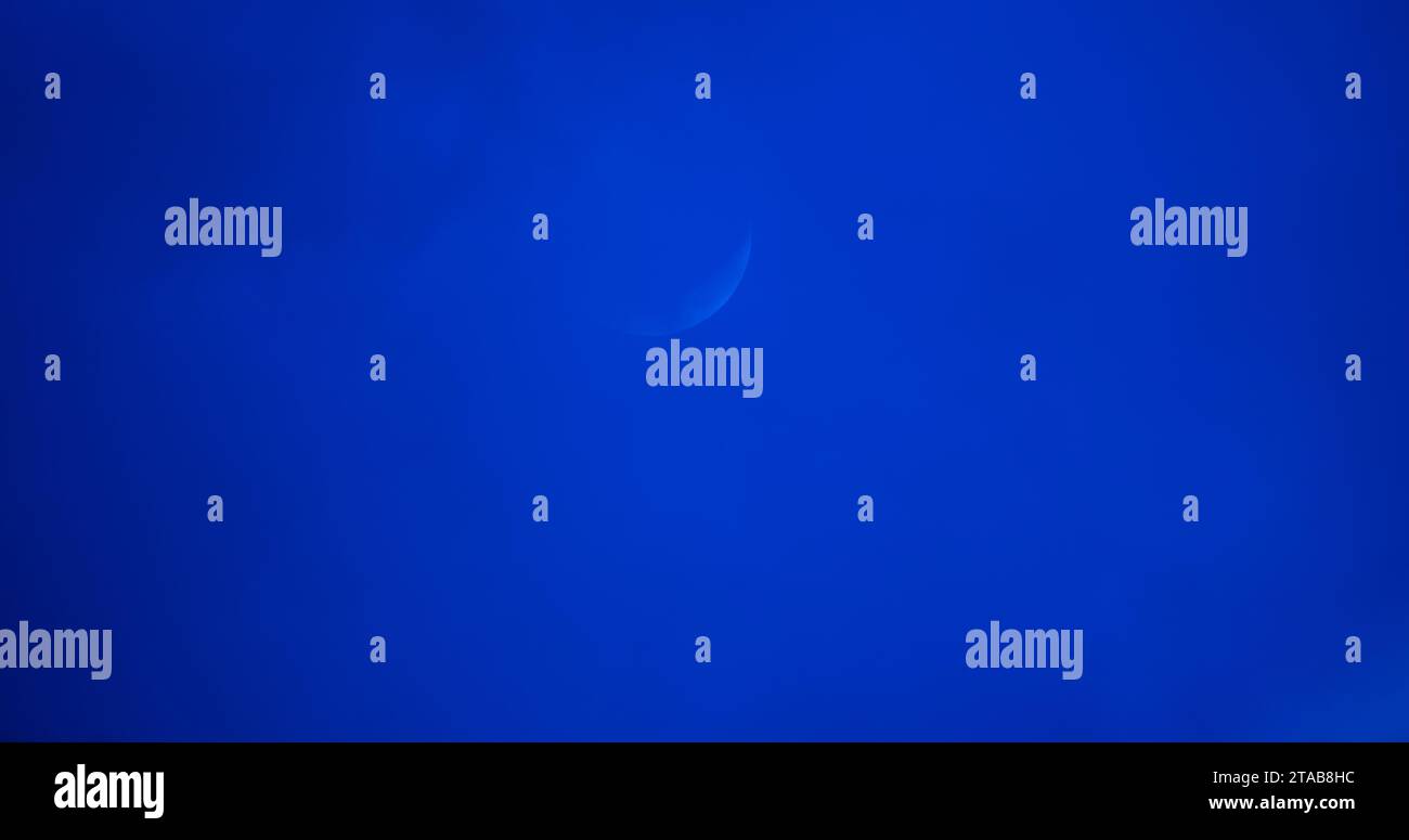 Crescent moon cloaked in a sky of deepest blue Stock Photo - Alamy