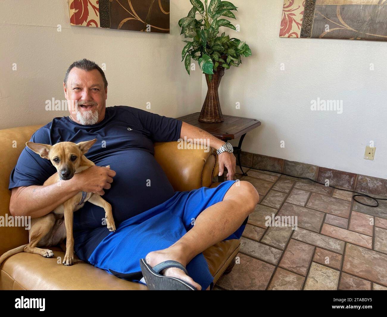 Michael Genaldi poses with his rescue dog Chico in the lobby of a ...