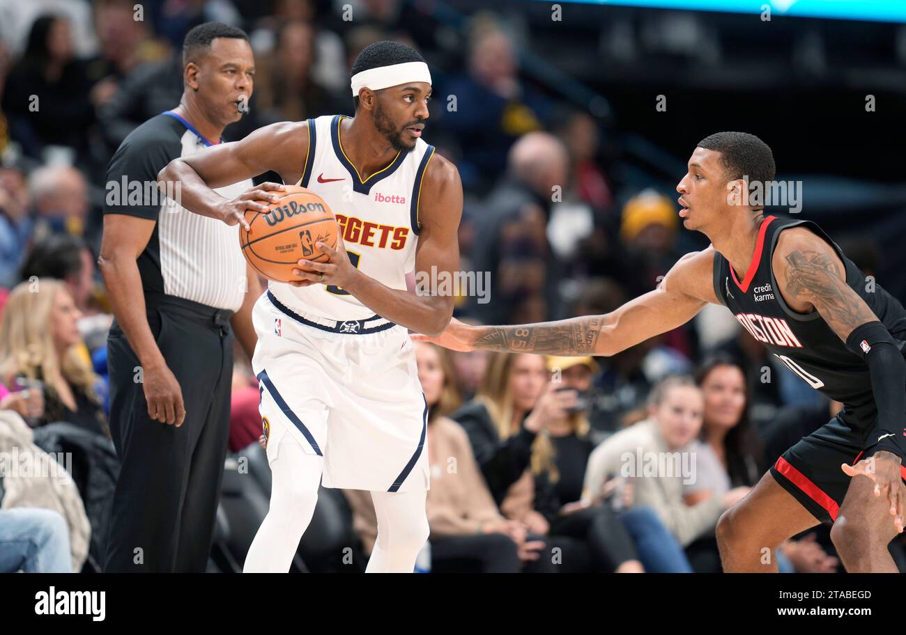 Denver Nuggets forward Justin Holiday, left, looks to pass the ball as ...