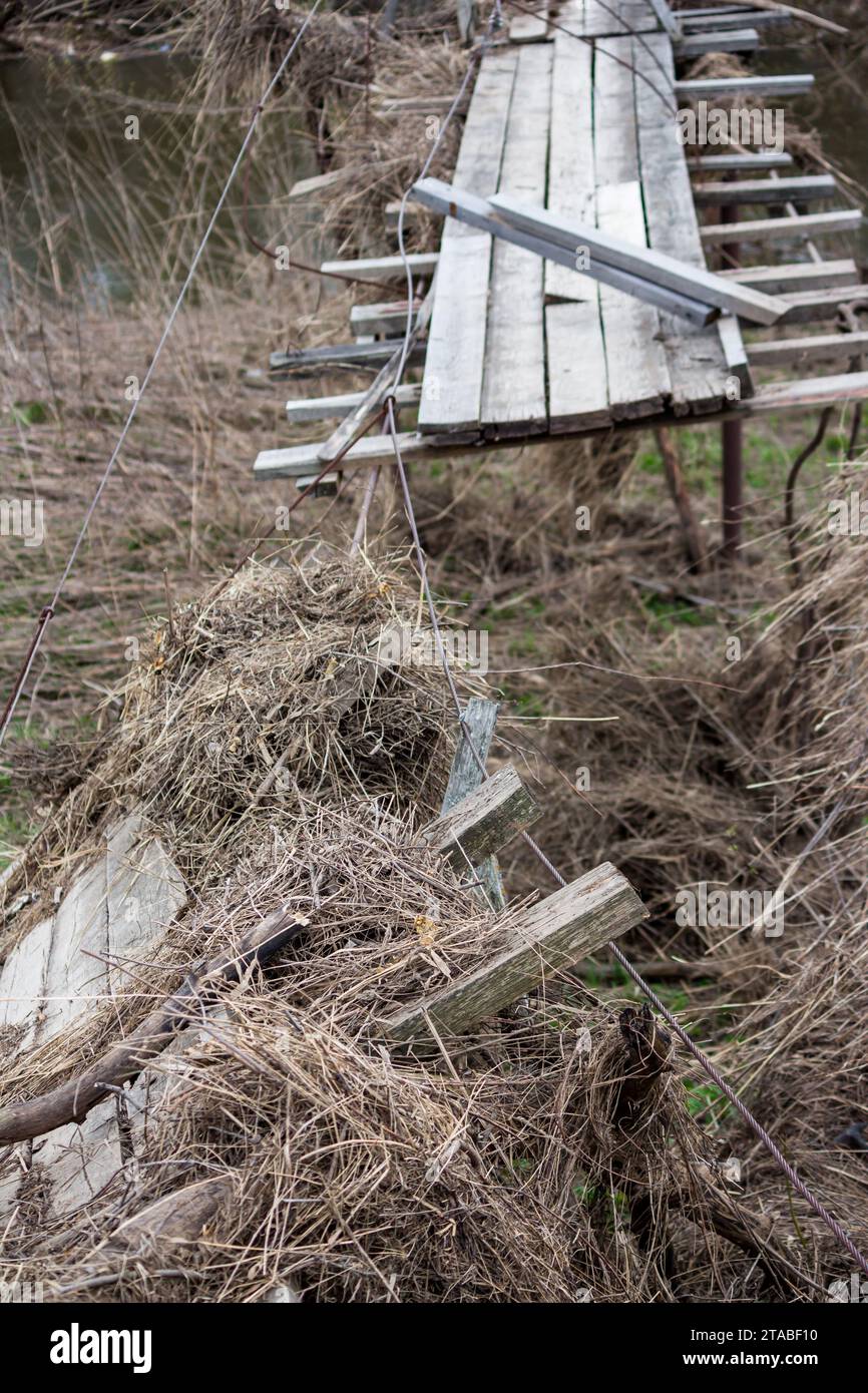 A broken pedestrian suspension bridge in the countryside after a spring ...