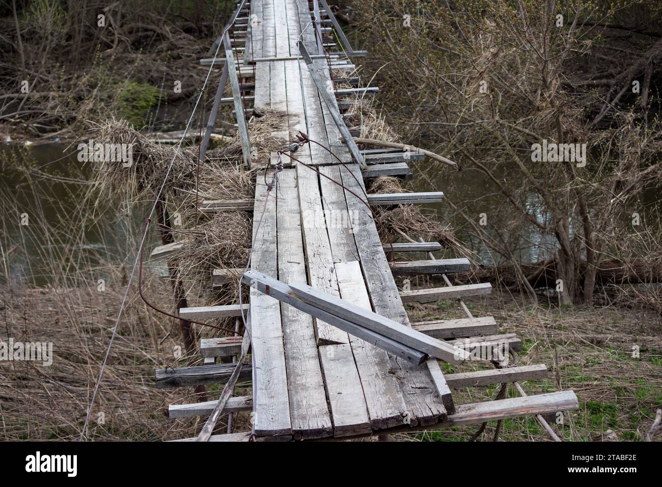 A broken pedestrian suspension bridge in the countryside after a spring ...