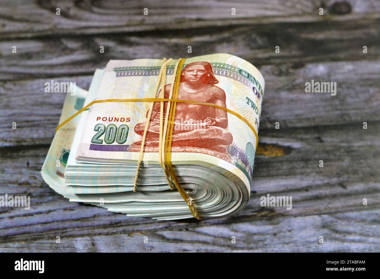 Folded Egyptian money isolated on wooden background, 200 LE 100 EGP LE ...