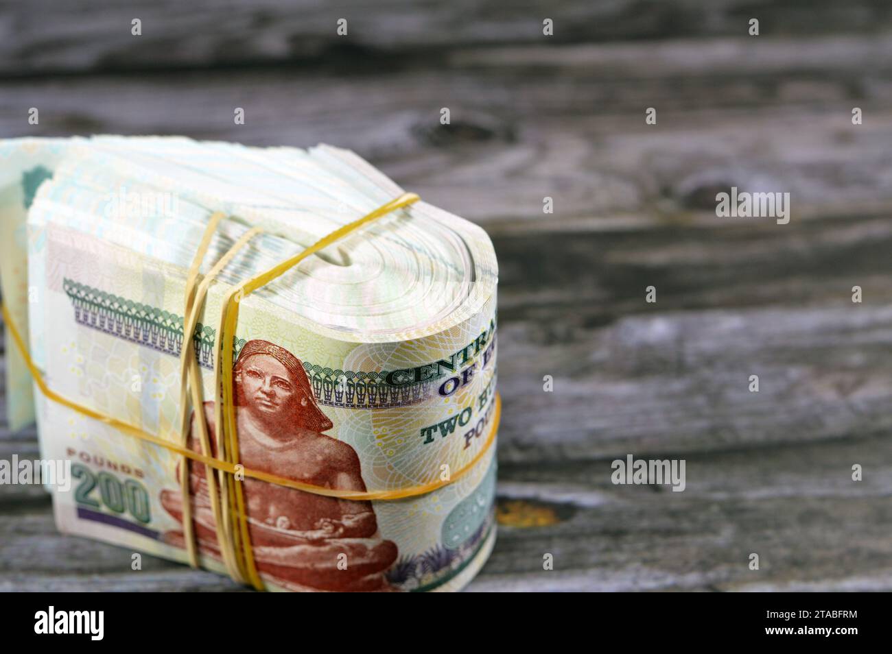 Folded Egyptian money isolated on wooden background, 200 LE 100 EGP LE ... Folded Egyptian money isolated on wooden background, 200 LE 100 EGP LE ...