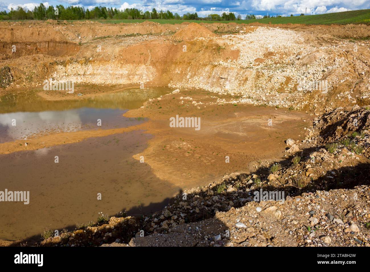 A large pit in a limestone quarry filled with clay at the bottom Stock ...