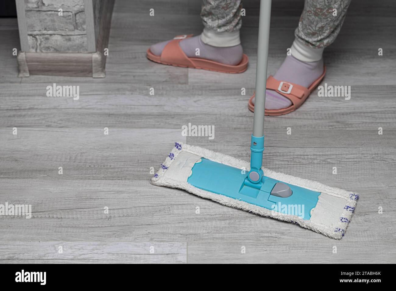 woman wiping the floor with a mop for dry cleaning Stock Photo - Alamy