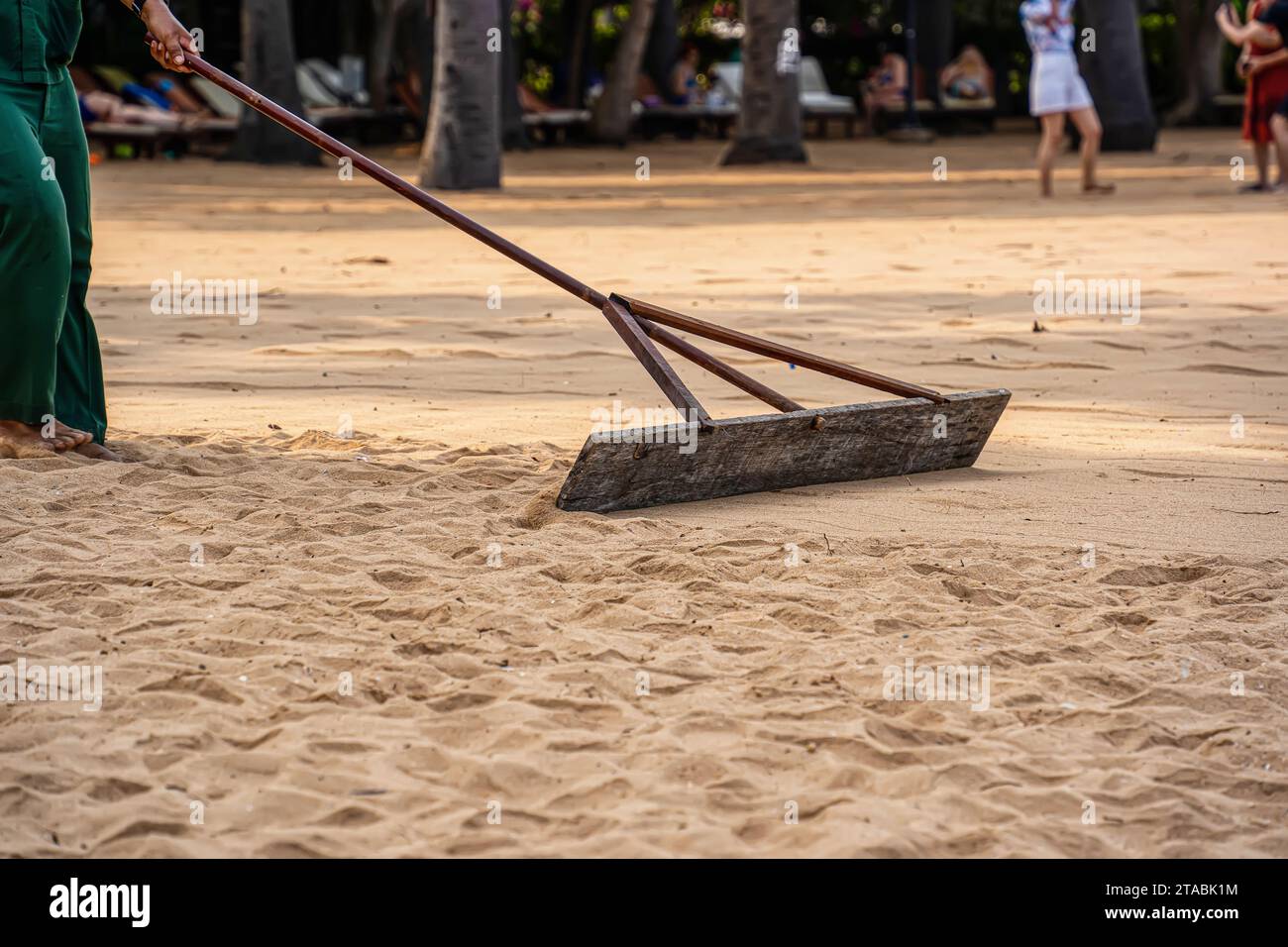 Smoothing the sand on the beach for beauty Stock Photo - Alamy