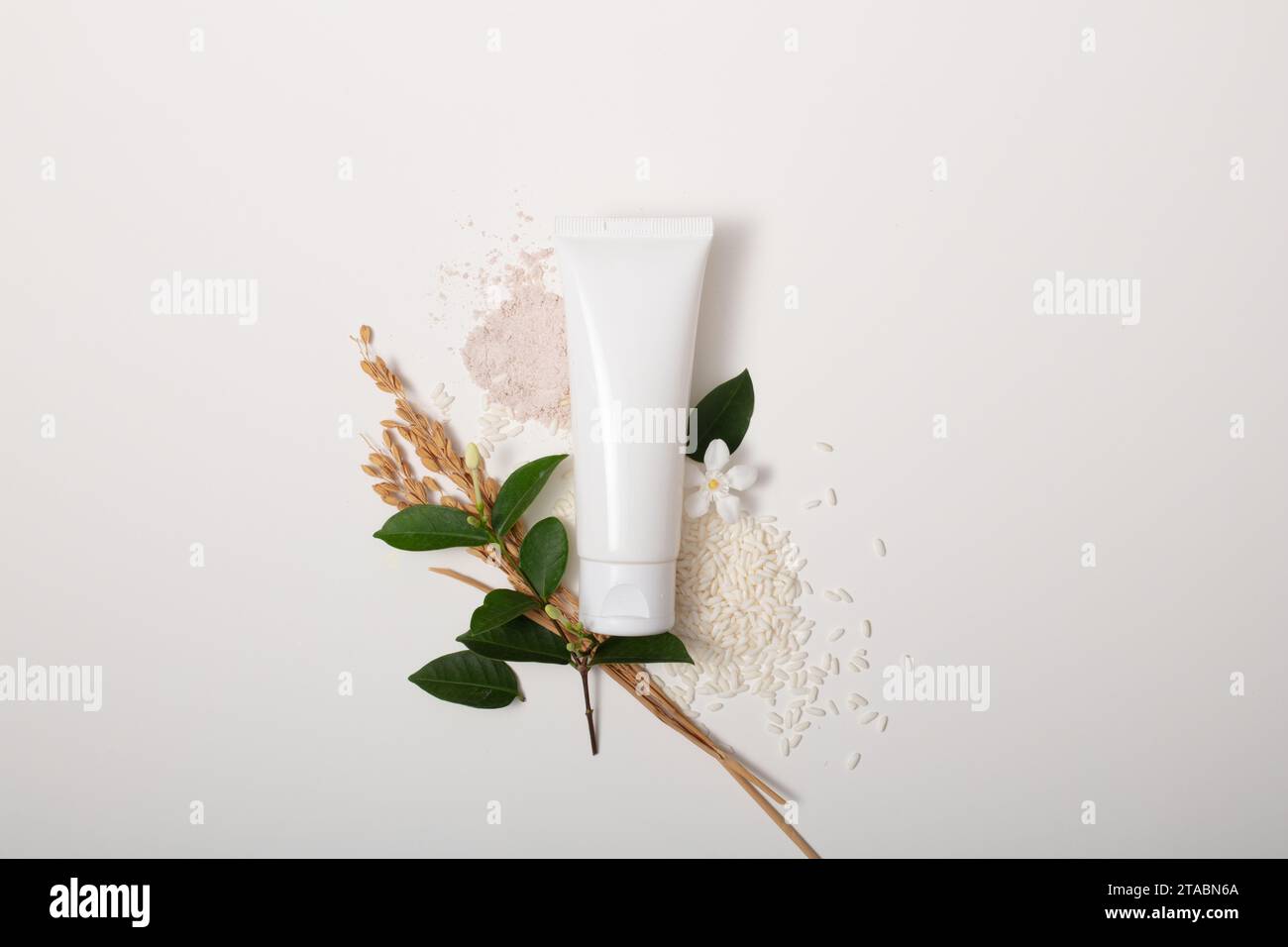 Close-up of an unlabeled cosmetic tube, rice bran powder, whole rice ...