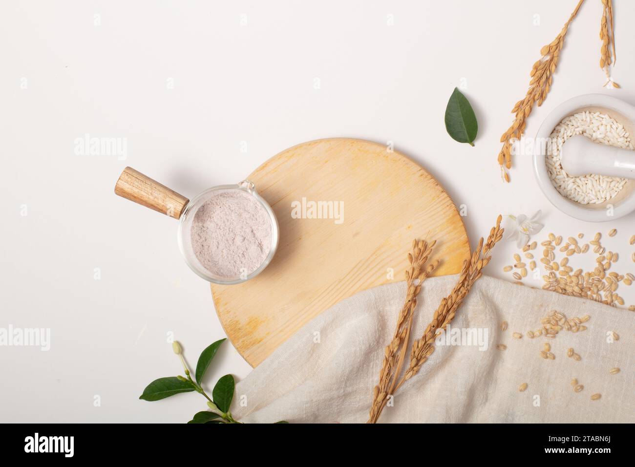 Whole rice, rice bran powder and props are arranged on a white ...
