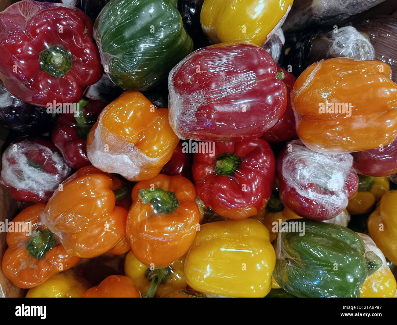 Plastic coated green, yellow, red bell peppers Stock Photo - Alamy