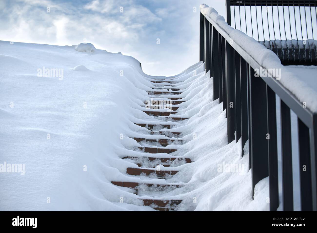 Winter scene where a set of stairs is almost completely covered in snow ...