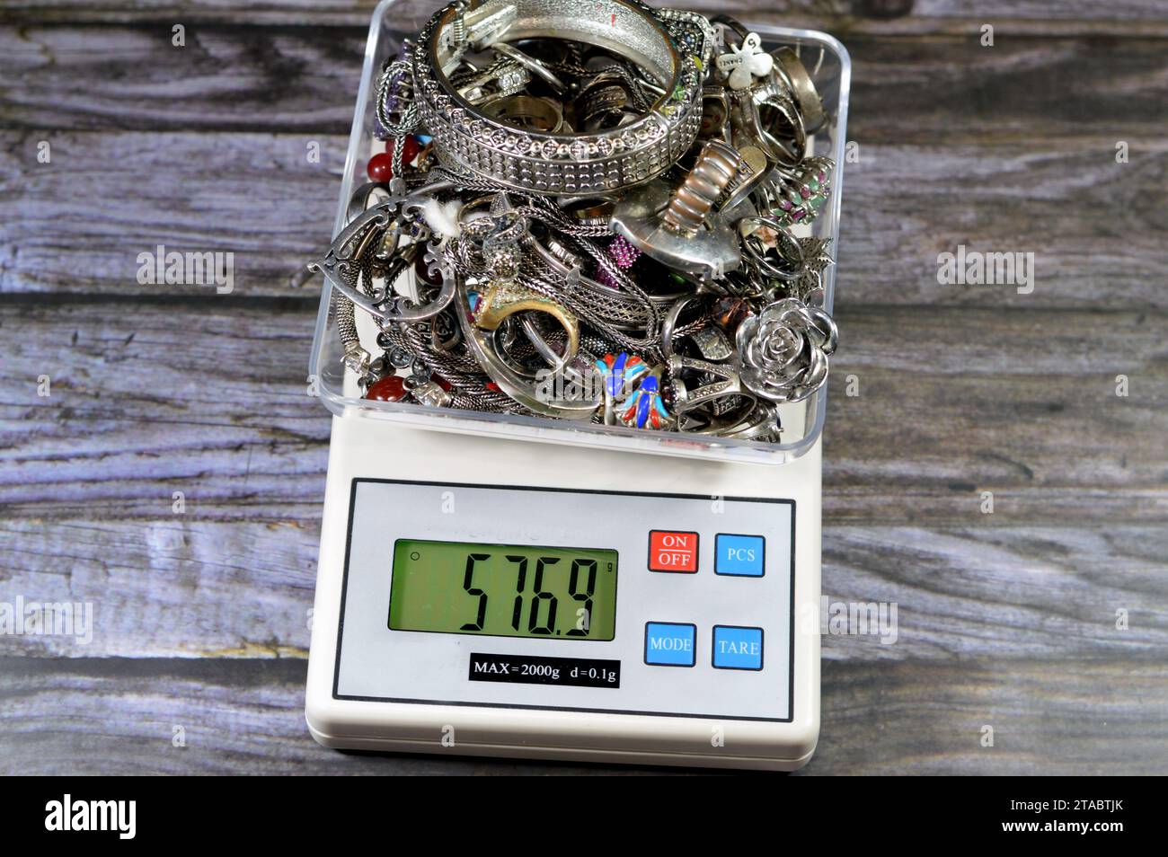 Pile stack of silver on a digital accurate scale in grams, bracelets ...