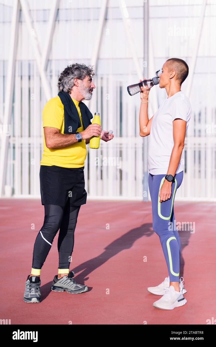 man drinking water with trainer before training Stock Photo - Alamy