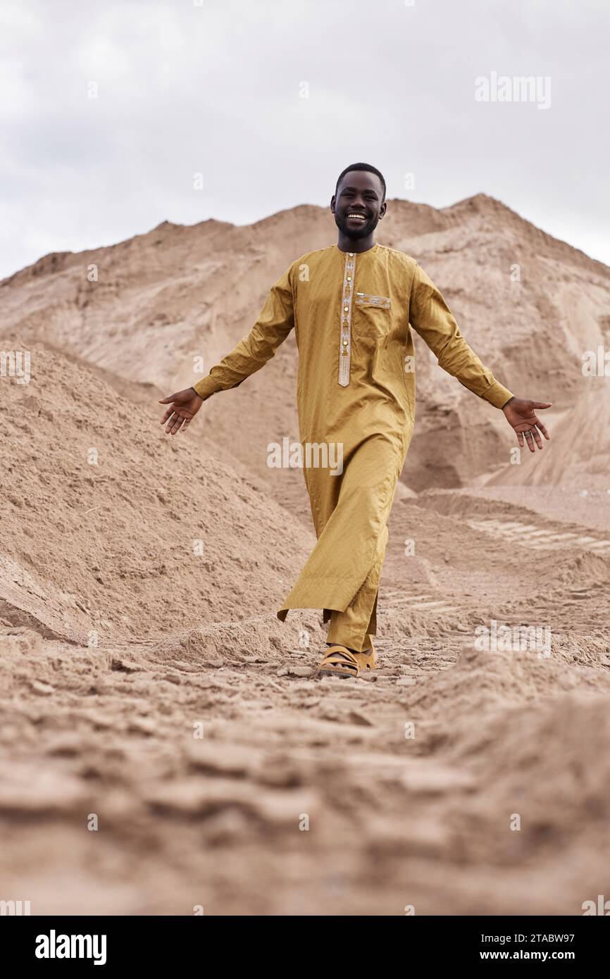 Vertical full length portrait of young Black man wearing traditional ...