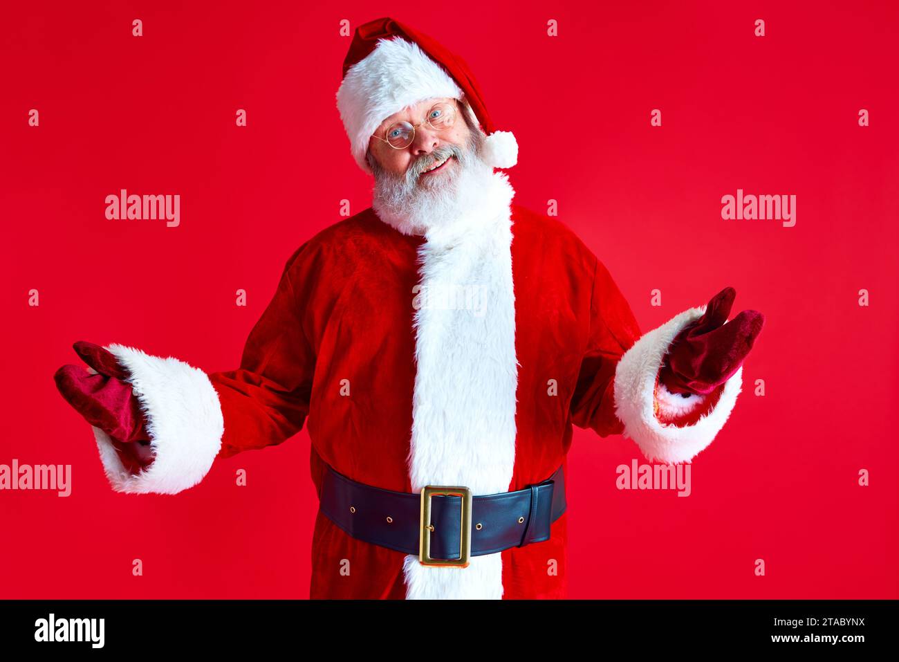 Mature man with long beard, kind eyes dressed as Santa with open arms ...