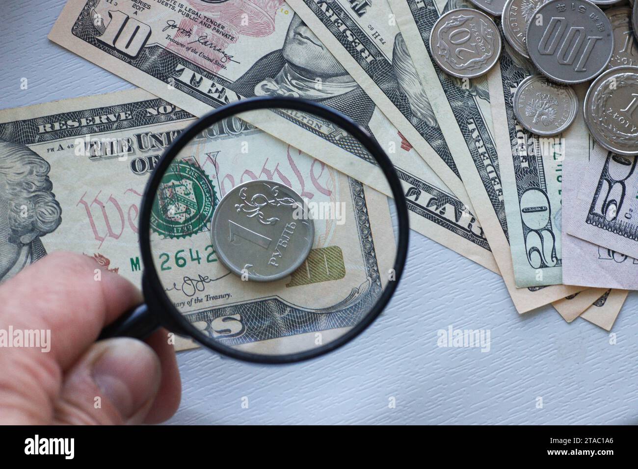 Magnifying glass, money and financial sanctions. A hand holds a ...