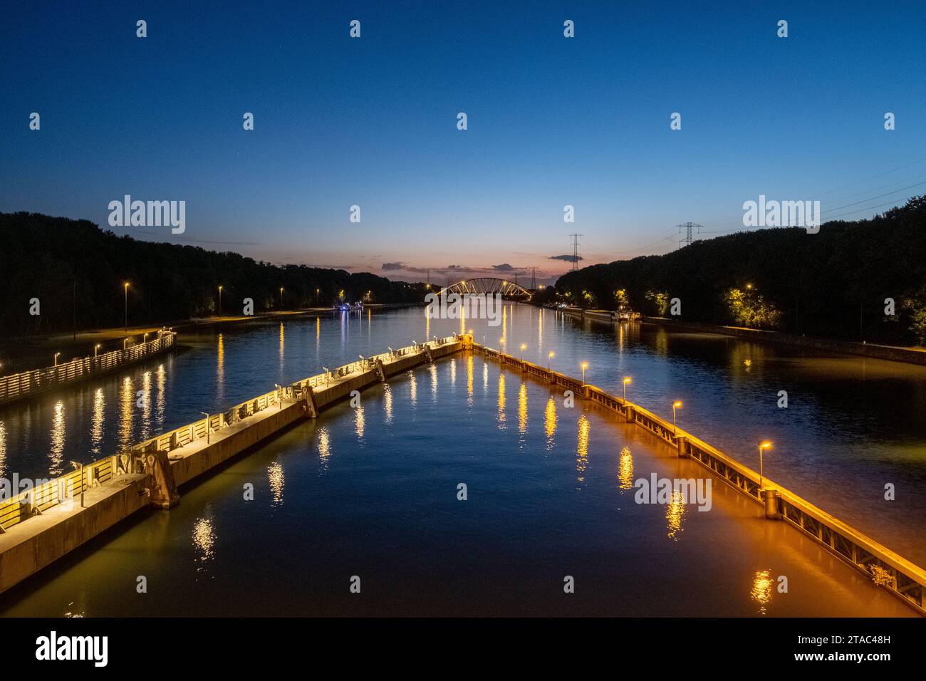 As twilight descends, this image showcases a river walkway illuminated ...
