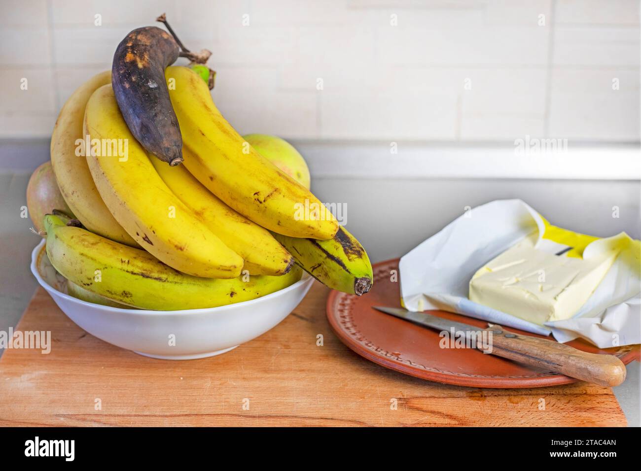 bunch of bananas with apples in a plate with banana oil in the kitchen ...