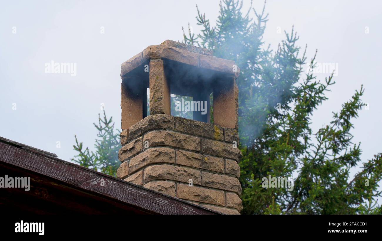 smoke from the chimney. A residential building in the suburbs on a ...