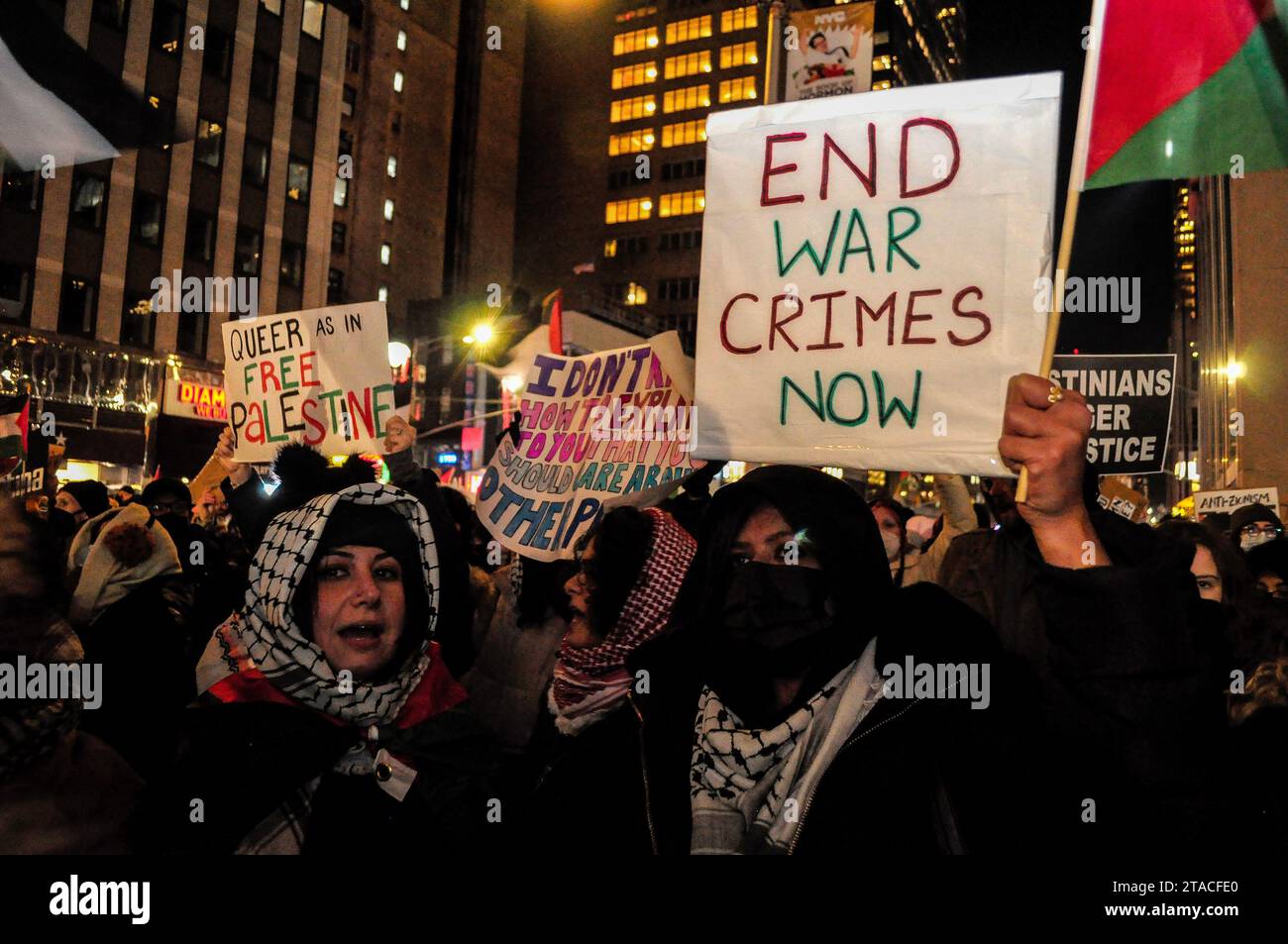 A protester, some wearing keffiyeh scarf, wave Palestinian flags and ...