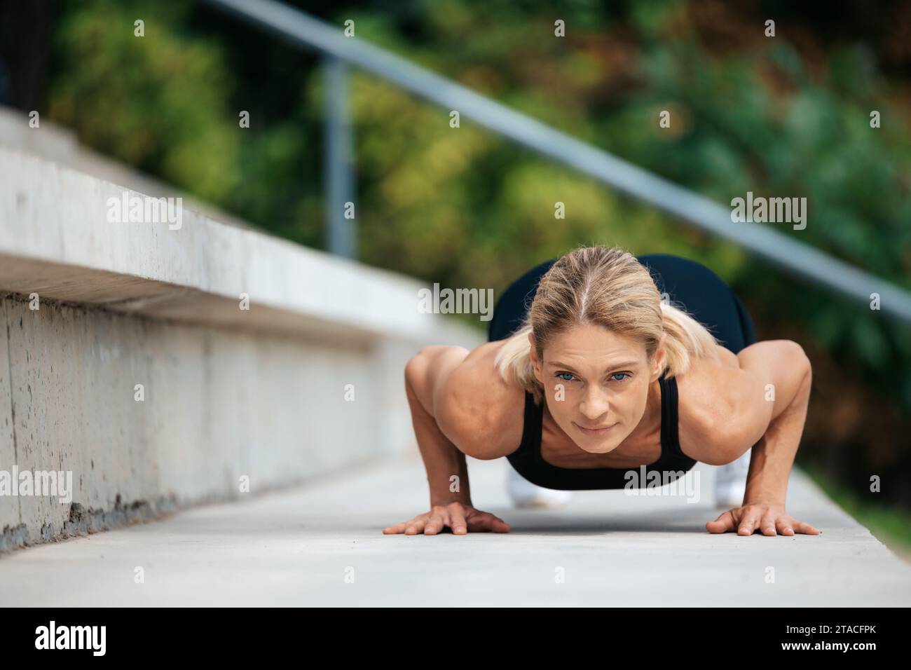 Blonde woman doing push ups outdoor Stock Photo - Alamy