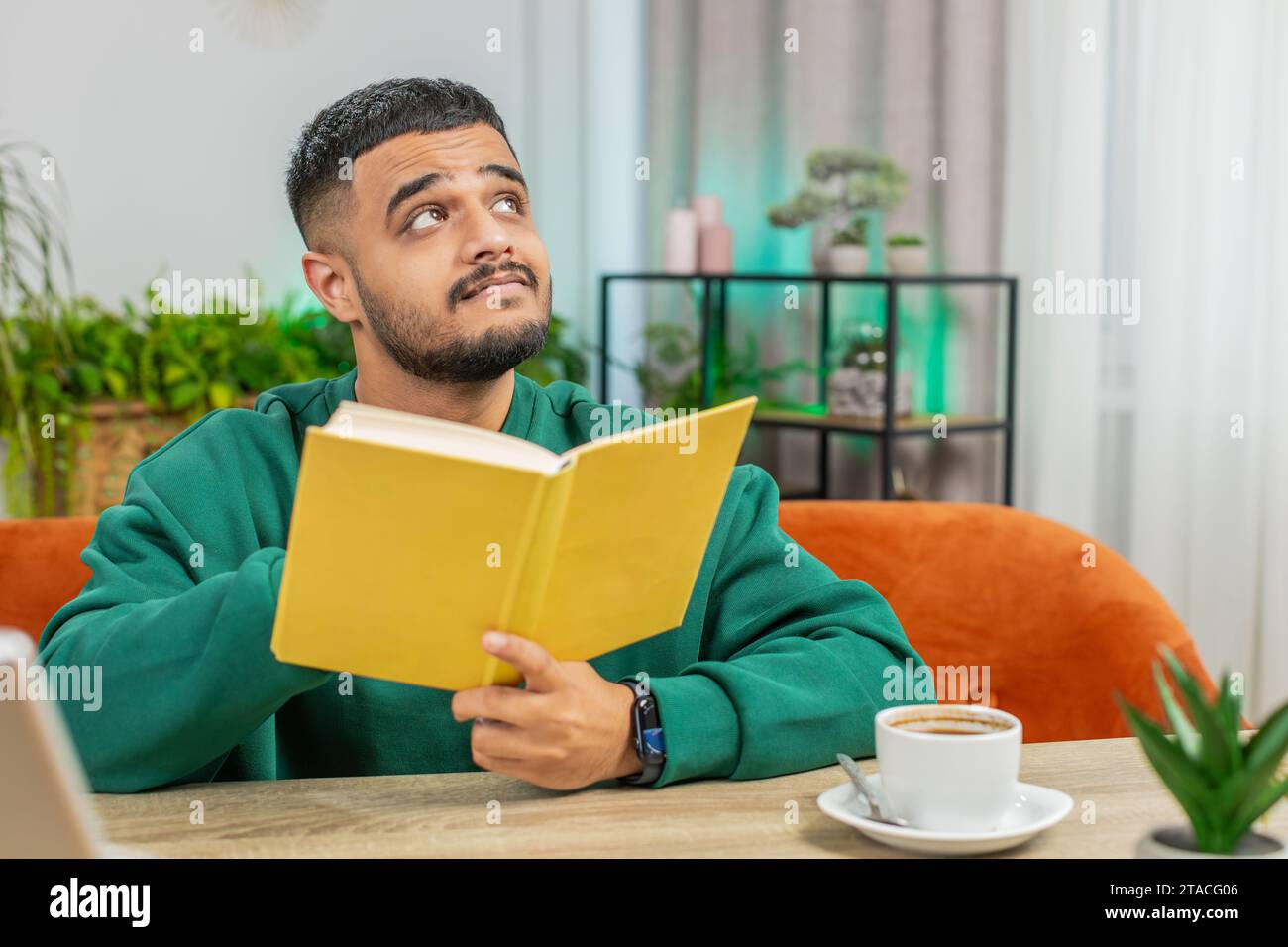 Indian man reading interesting book, turning pages smiling enjoying ...