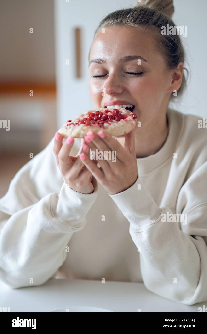 Close up of a girl eating sandwich and looking enjoyed Stock Photo - Alamy