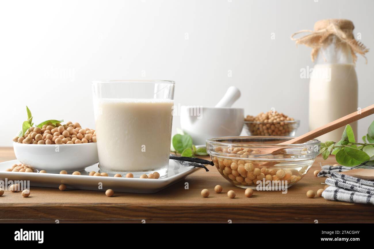 Glass with freshly brewed naturally soy drink with bowl with soaking ...