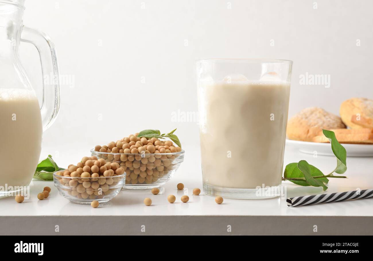 Breakfast with milk and soy bread on white table with bowls full of ...