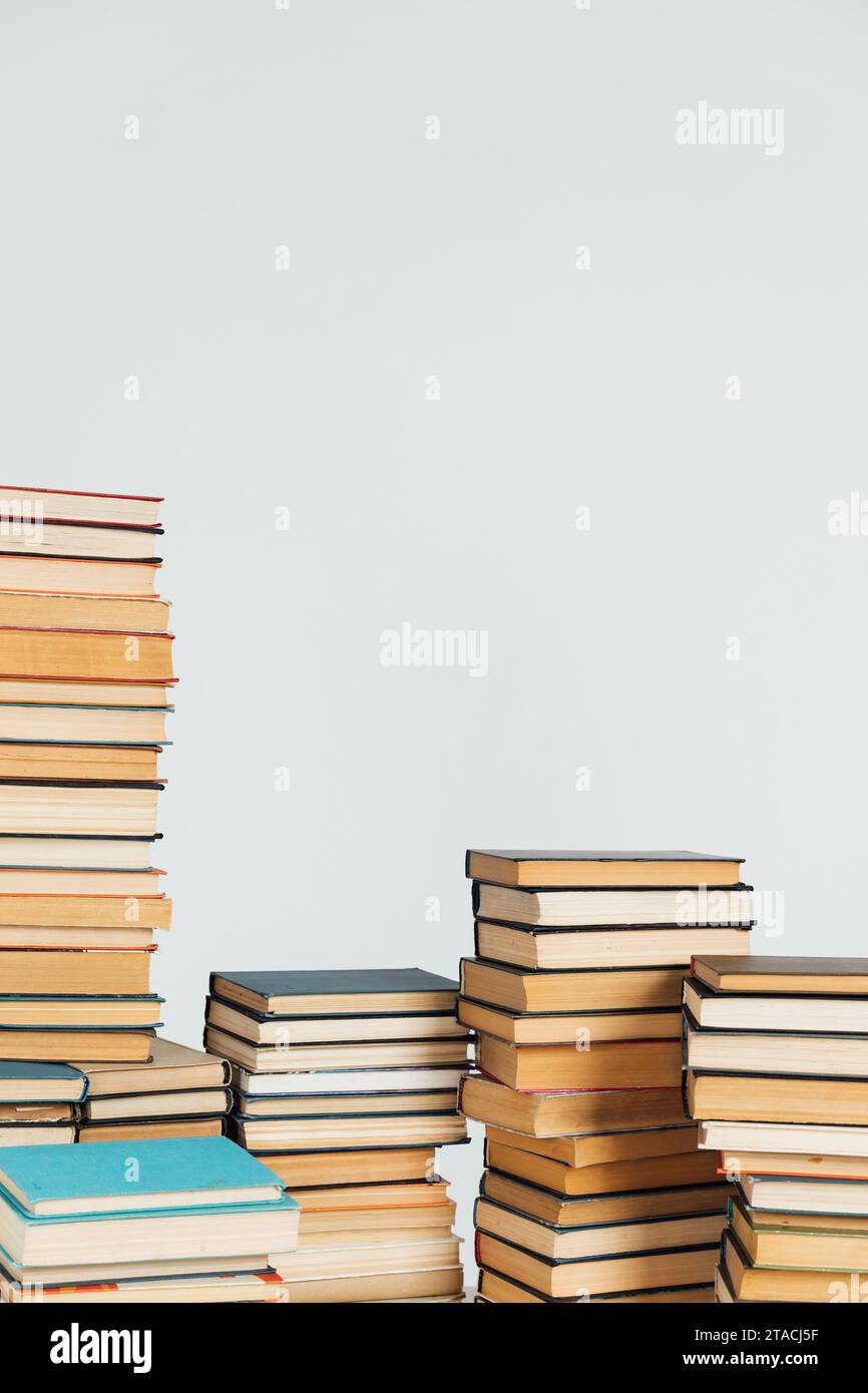 Lots of stacks of old educational books on white background university ...