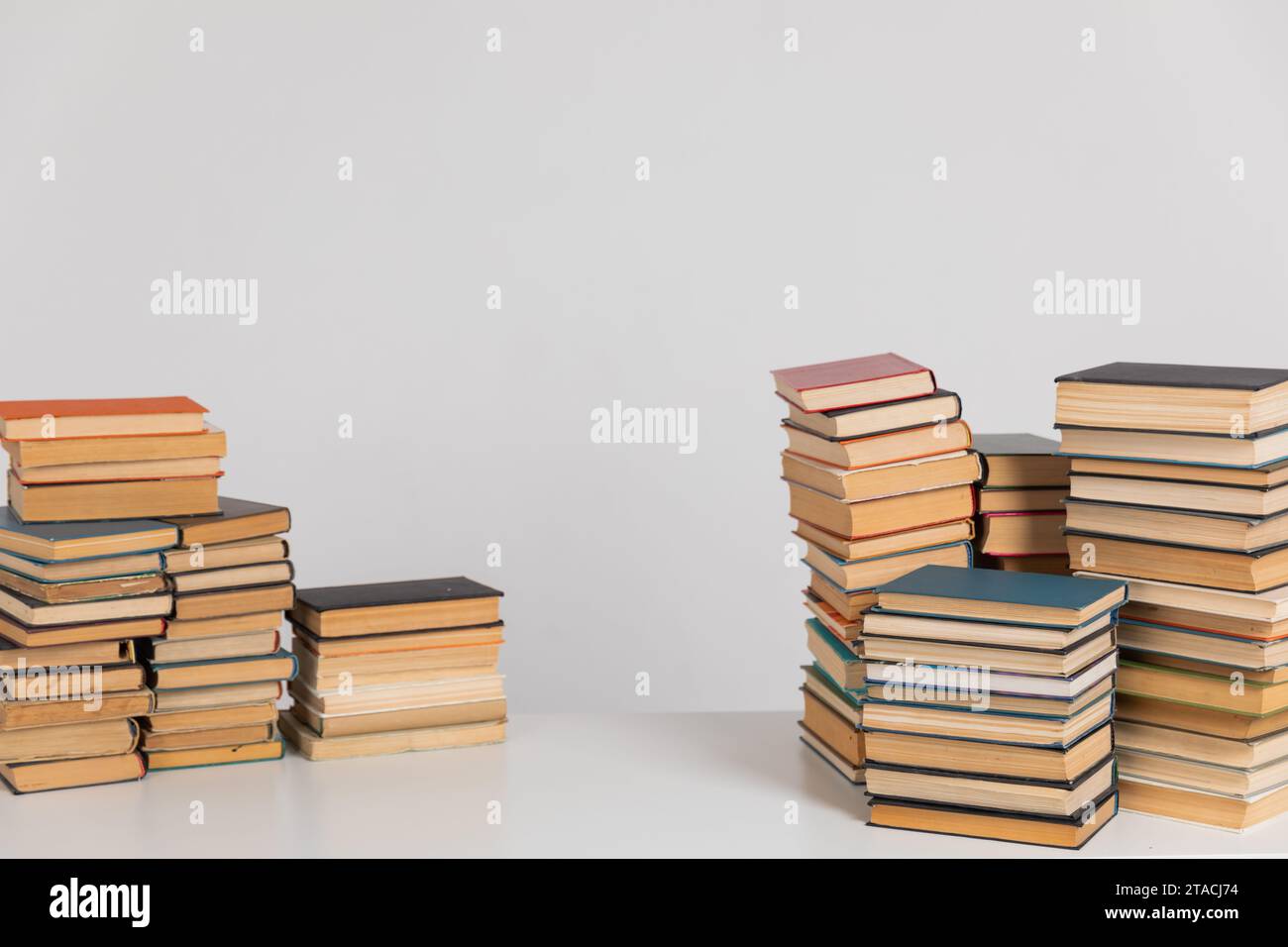 Lots of stacks of old educational books on white background university ...