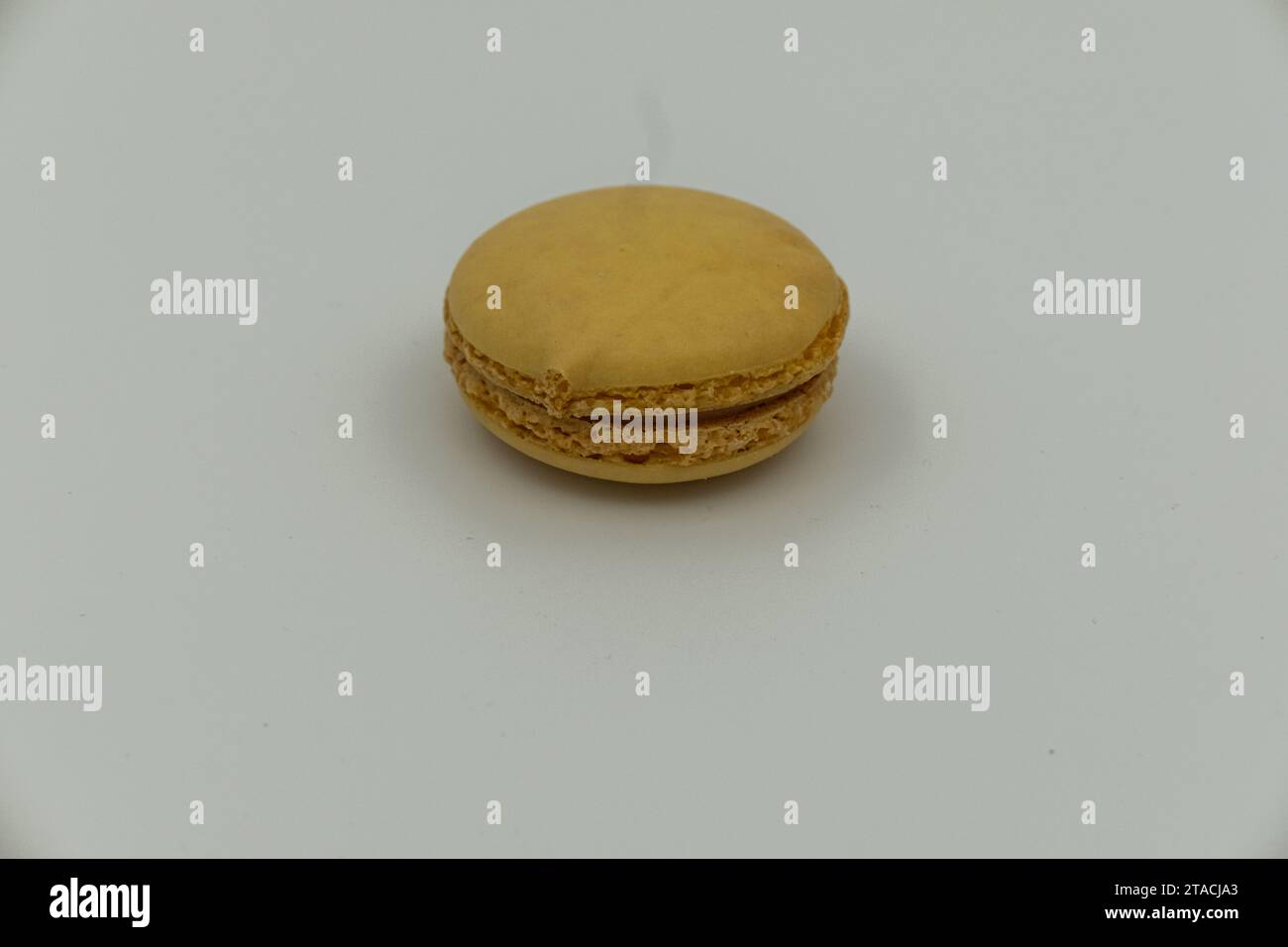 Yellow macaron in front of a white background Stock Photo - Alamy