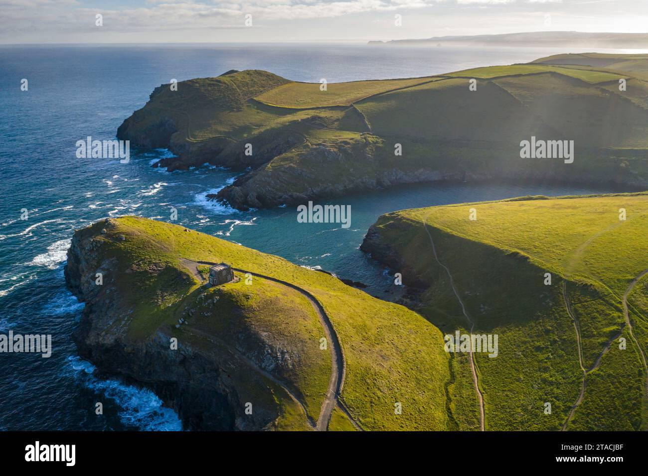 Aerial view of Doyden Castle and Port Quin surrounded by rugged Cornish ...
