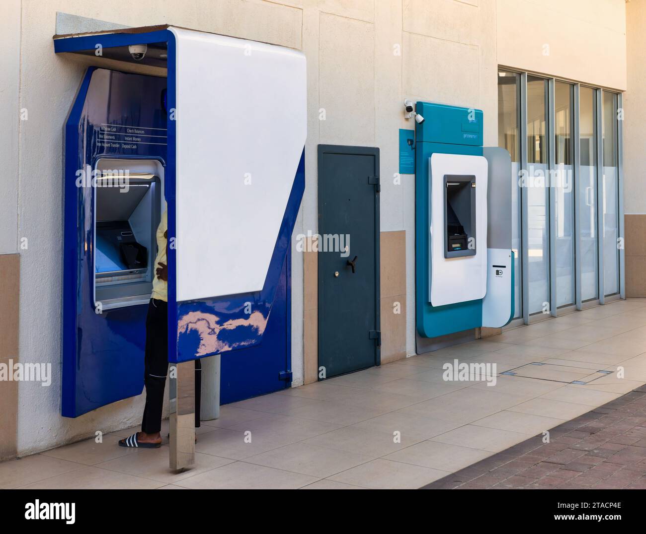 african american young person using an ATM machine in a shopping ...