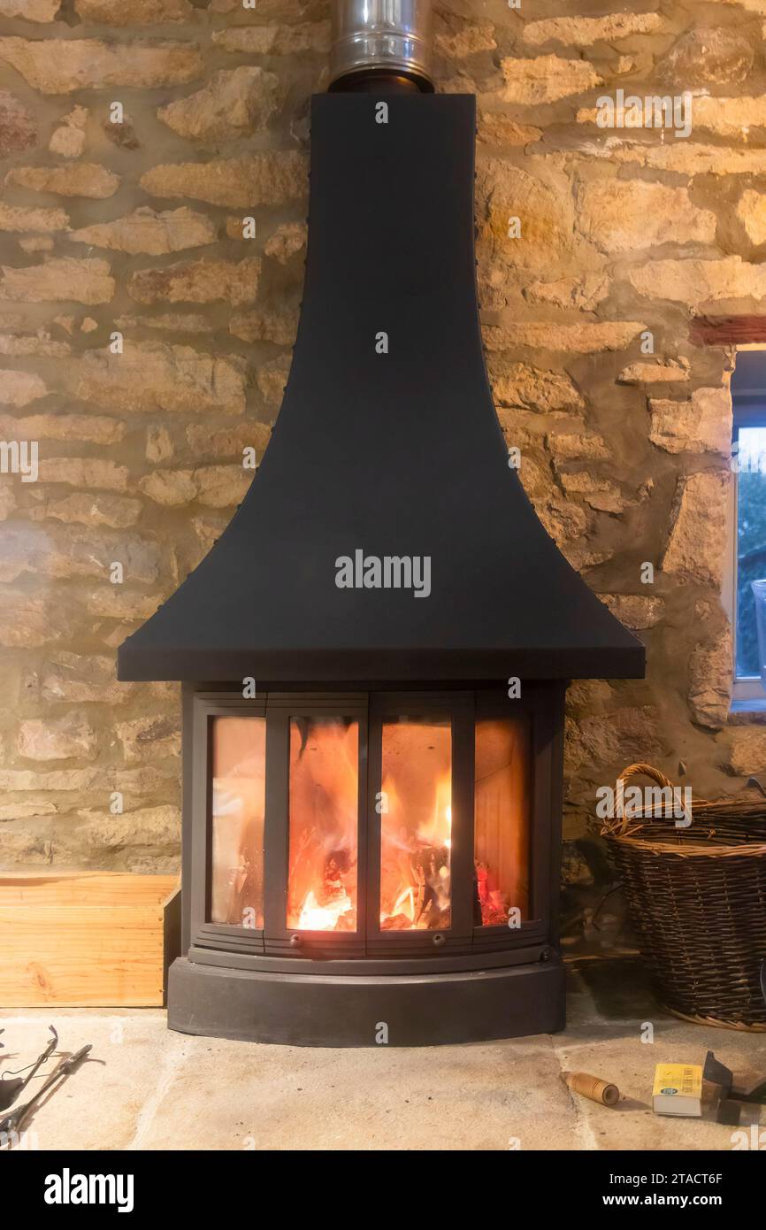 flames in a log burning stove with stone wall Stock Photo - Alamy