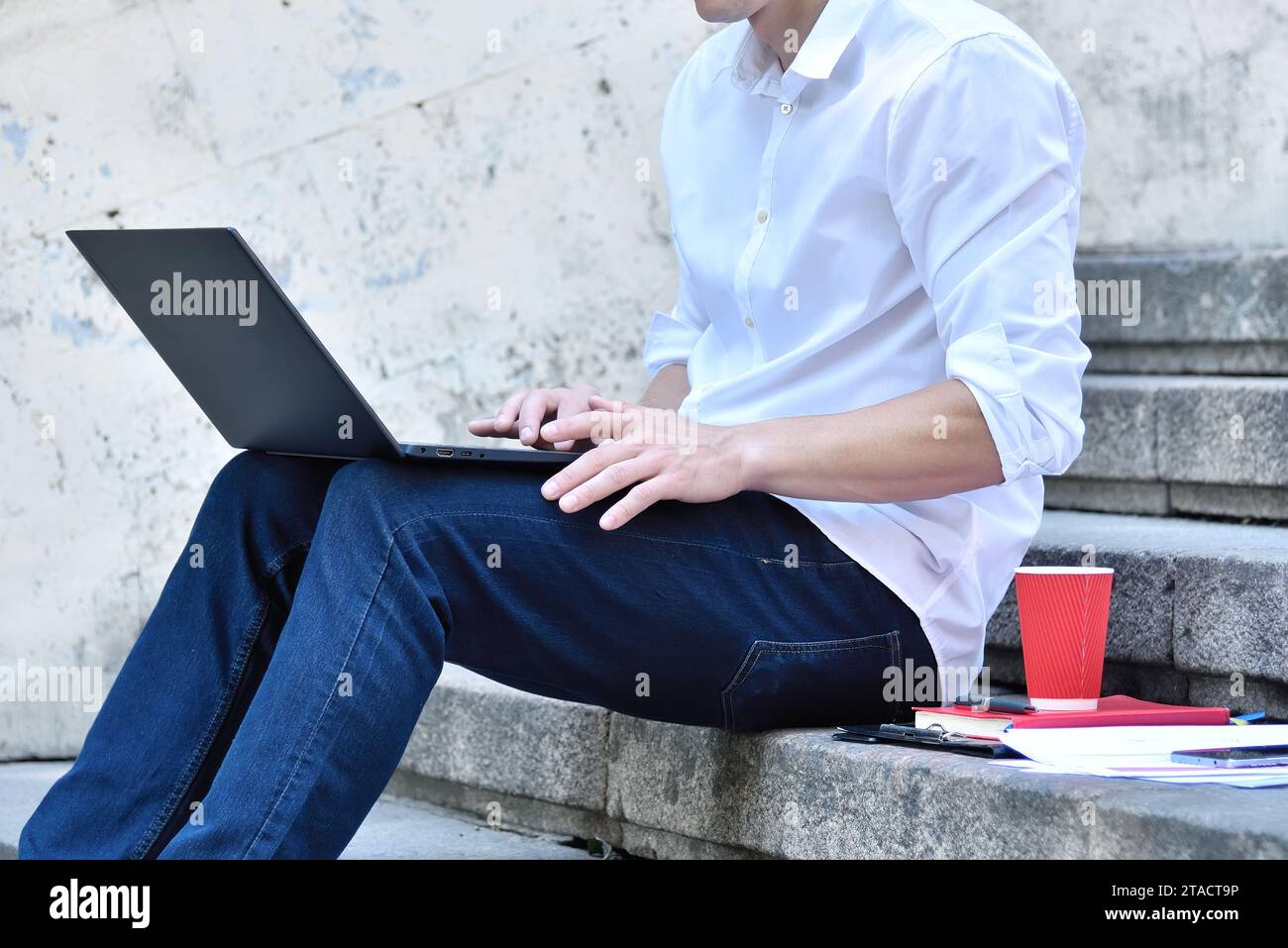 Trader man sitting on stairs and typing on laptop. Finance and trade ...