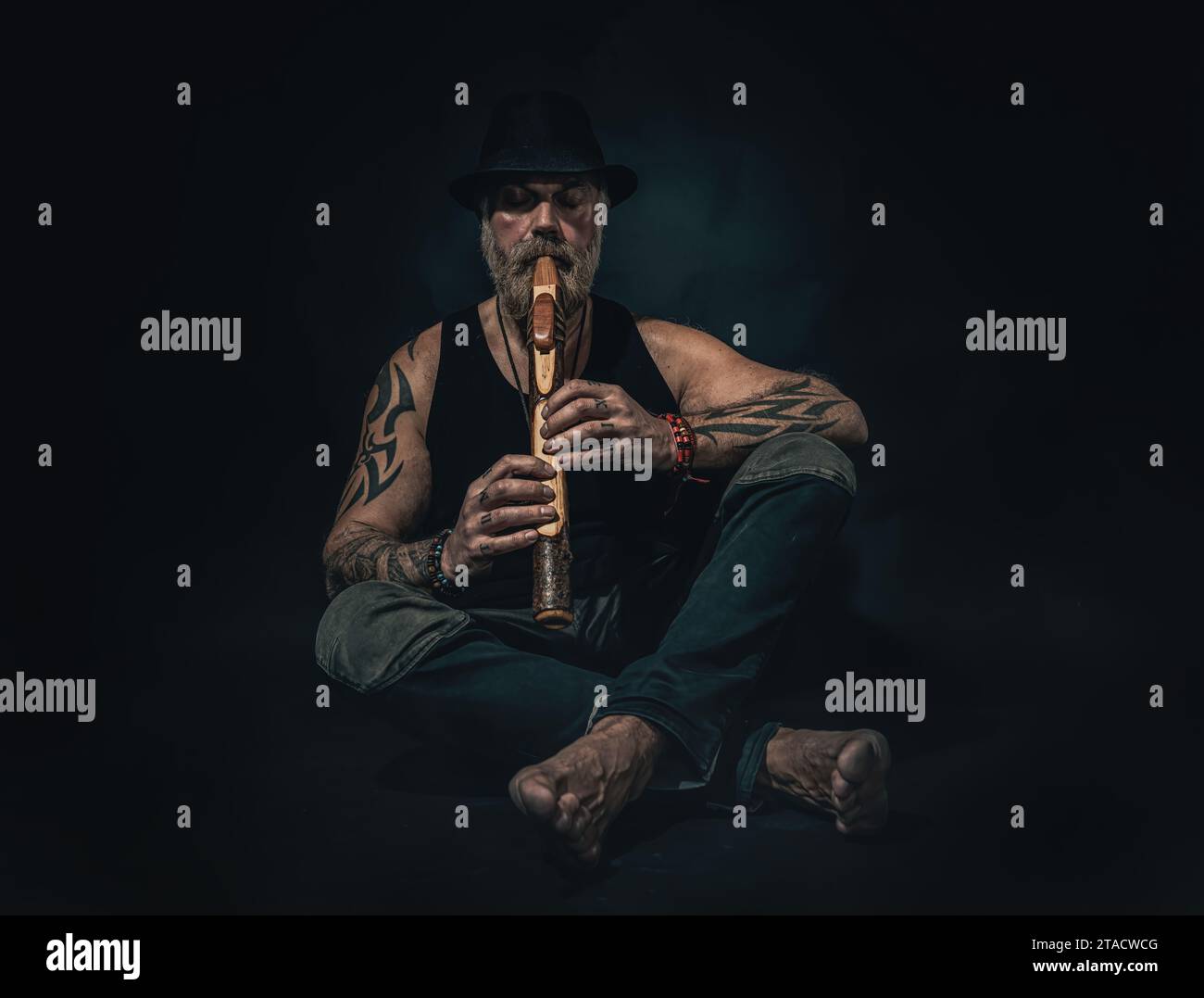 Man plays a native american flute in a studio, atelier photos, black ...